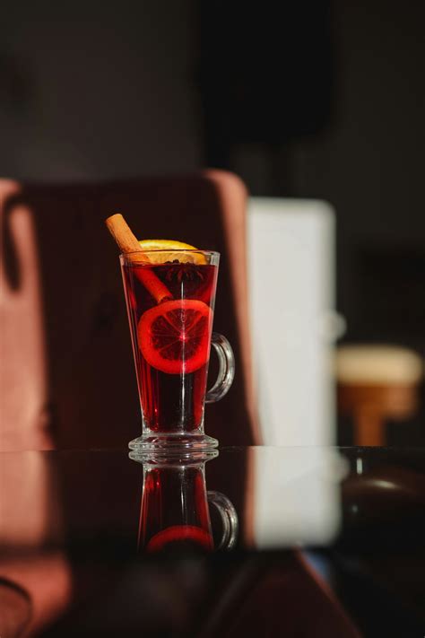 오렌지 한 조각을 얹은 빨간 음료 사진 Unsplash의 무료 칵테일 이미지