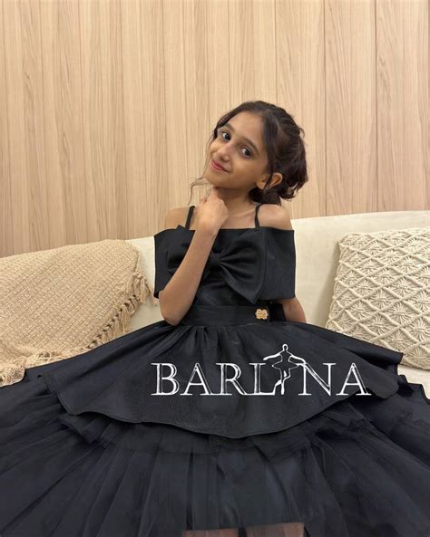 فستان سهرة أسود بكتف وشال ارجواني إطلالة كاملة تنبض بالأنوثة