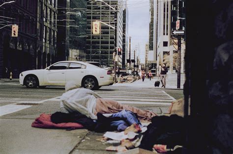 Homeless Person Sleeping On City Sidewalk With Traffic Photo Free Car
