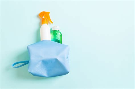 선크림 스프레이 선스린 선블록 바디 로션 Spf 크림이 가득한 여성 화장품 가방의 탑뷰를 복사 공간이 있는 파란색 배경에 있습니다 바로 위의 밝은 여름 컨셉 가방에 대한