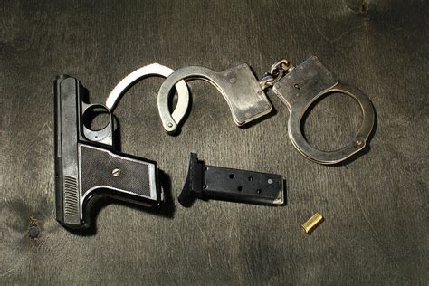 Gun And Handcuffs On Black Wooden Background Photograph By Nikolay Lebedev Fine Art America