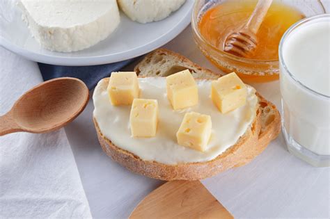 치즈와 흰 접시 Kefir와 블루 냅킨에 빵 한 조각 꿀 미니 부드러운 치즈와 함께 샌드위치에 꿀 프랑스 흰색 배경 미국의 요리에서 아침 식사 0명에 대한 스톡 사진 및