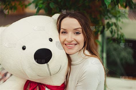 漂亮的女孩抱着一只白色的大泰迪熊