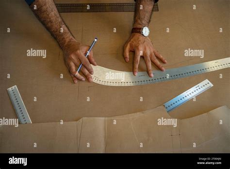 A Male Designer Using Pattern Making Tools For A Menswear Collection In His Studio Stock Photo