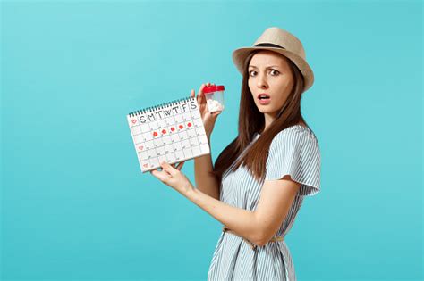 파란색 배경에 고립 된 생리 일 체크 드레스 흰색 병 약 여성 기간 일정을 잡고 슬픈 여자의 초상화 의료 보건 부인과 개념 공간에 복사 합니다 건강 진단에 대한 스톡 사진