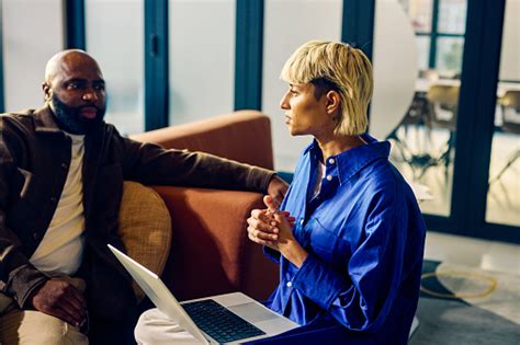 짧은 금발 머리를 한 여성과 창의적인 사무실 환경에서 아프리카계 미국인 남성 간의 전문적인 토론 협업 팀워크와 비즈니스 컨셉의 기술 통합 25 29세에 대한 스톡 사진 및