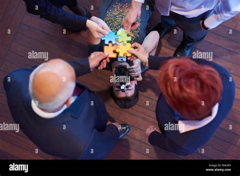 Business People Group Assembling Jigsaw Puzzle And Represent Team