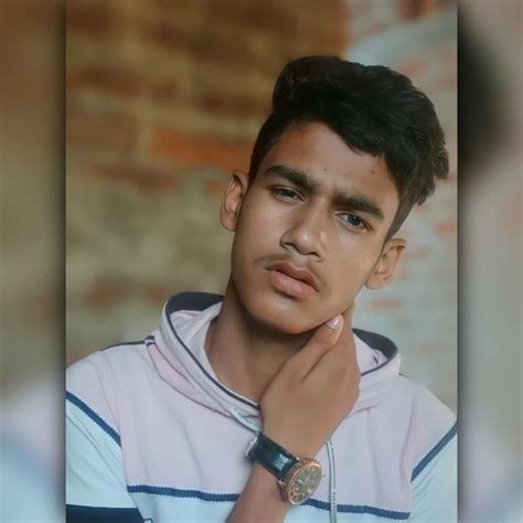 A Young Man With A Watch On His Wrist Looking At The Camera While