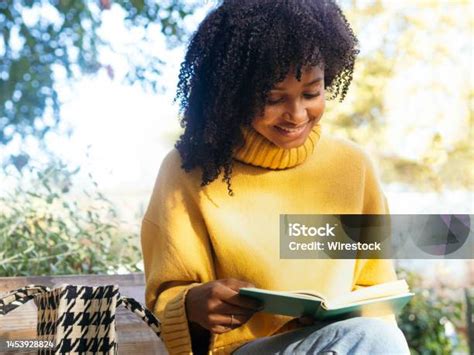 노란 스웨터를 입고 야외에서 책을 읽는 스페인의 아프리카 여성 곱슬 머리에 대한 스톡 사진 및 기타 이미지 곱슬 머리 노랑 사람 얼굴 Istock