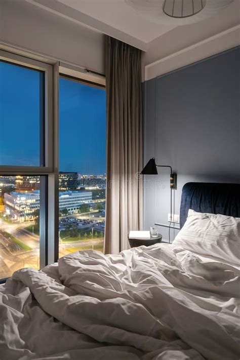 Light From A Wall Sconce Above A Bedside Table With A Book In Bedroom