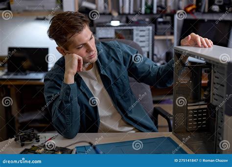 Computer Repairman Checking A Computer Component After Disassembling It