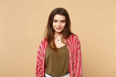 캐주얼 서 있는 매력적인 귀여운 젊은 여자의 초상화 스튜디오에서 파스텔 베이 지 벽 배경에 고립 된 찾고 카메라 사람들은