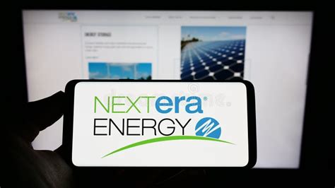 Person Holding Cellphone With Logo Of Us Energy Company Nextera Energy