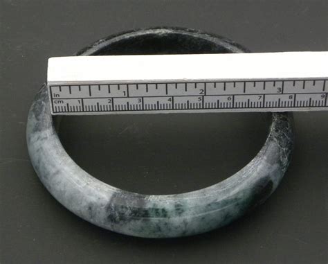 A Chunky Burmese Jade Bangle With Pale Milky Green Colours