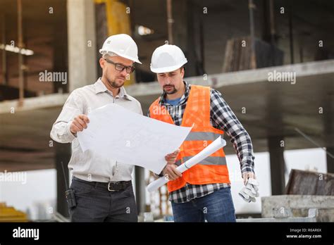 Male Architect And Developer Discussing Blueprints Of An Architect