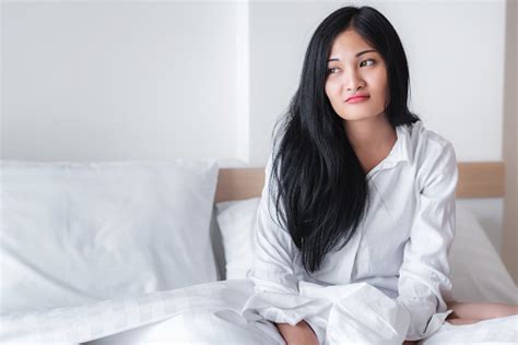 아름 다운 젊은 아시아 여자는 일어나서 흰 침대에서 아침에 흰 셔츠와 함께 행복 한 미소를 만들 가정의 방에 대한 스톡 사진 및 기타 이미지 Istock