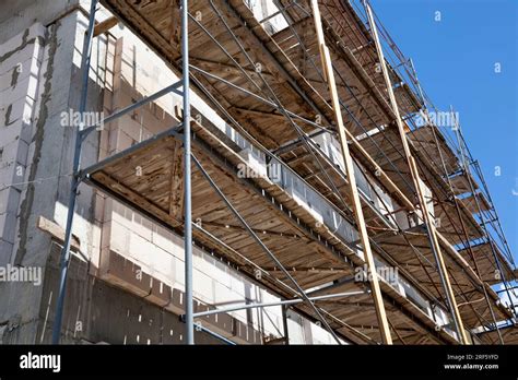 Building A New Home On The Building Scaffolding For Construction And Stucco Walls Of Building