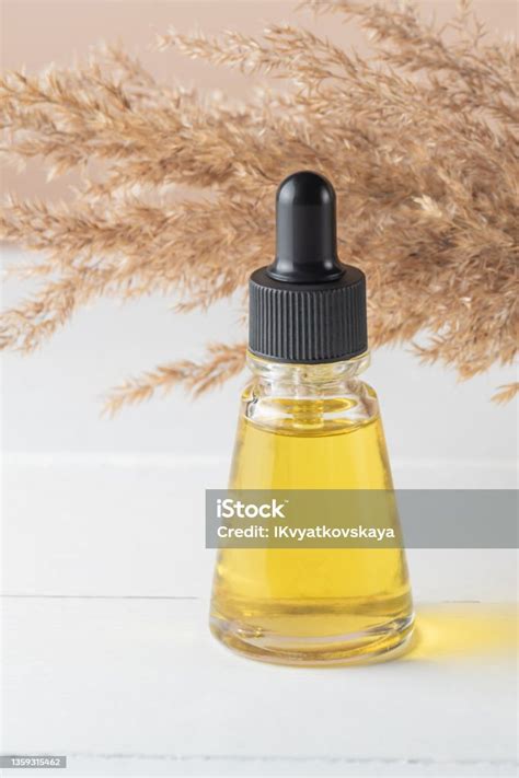 흰색 배경에 파이펫이있는 빈 유리 에센셜 오일 병은 건조한 야생 대간을 장식했습니다 천연 화장품을 가진 스킨 케어 컨셉 페이스