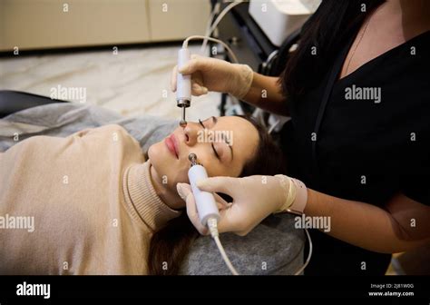 Close Up A Middle Aged Caucasian Pretty Woman Receives Facial Microcurrent Treatment From