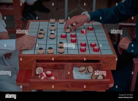 traditional qatari men playing dama board game in katara beach close up