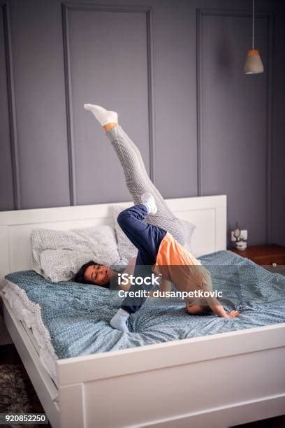 쾌활 한 젊은 어머니는 곡예와 아침 함께 스트레칭 하 고 그녀의 행복 한 작은 유아 아이 함께 침대에 누워 가정 생활에 대한 스톡 사진 및 기타 이미지 Istock