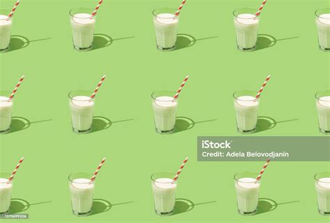 파스텔 녹색 배경에 우유 와 빨간색과 흰색 종이 빨대 의 유리로 만든 창조적 인 패턴 복고풍의 미적 스타일 최소한의 창조적 인 개념 1960 1969 년에 대한 스톡 사진