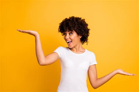 그녀는 좋은 사랑 스러운 매력적인 명랑 기쁜 미친 낙관적 물결 모양의 머리 소녀 두 손바닥을 들고의 초상화 밝은 생생한 광택