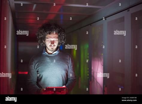 Male IT Engineer Working On A Tablet Computer In Server Room At Modern Data Center Stock Photo