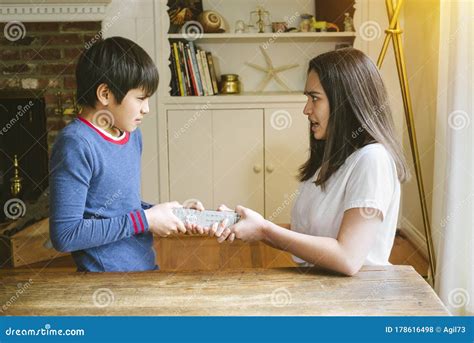 Two Siblings Argue Over The Remote Control During Quarantine Concept Fighting Boredom