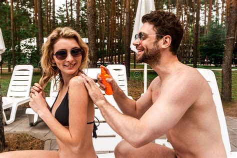 Cheerful Young Man Covering His Female Companion Exposed Body Parts