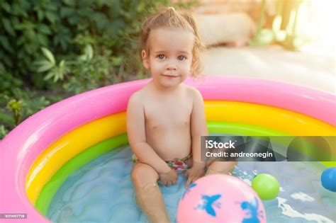 아이 들 팽창 식 아기 수영장에서 노는 아이 들 수영 하 고 다채로운 정원 놀이 센터에서 시작 뜨거운 여름 날에 물 장난감을가지고 노는 행복 한 어린 소녀 뒤뜰에 있는 옥외