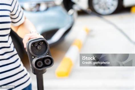 Ev 충전 소에서 Ev 충전기 커넥터를 들고 있는 여성 교류에 대한 스톡 사진 및 기타 이미지 교류 급유 녹색 기술 Istock