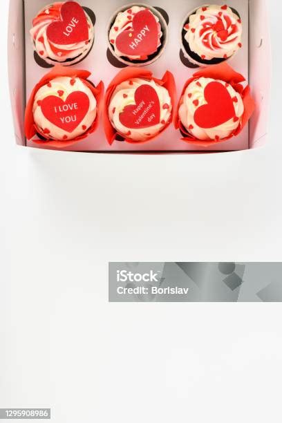 상자에 컵 케이크 흰색 배경에 다른 라벨이있는 열린 상자에 하트 모양의 컵 케이크는 아래 텍스트 복사 공간을위한 장소입니다