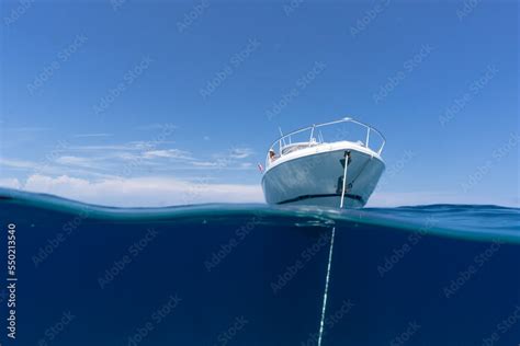 Luxury Boat Sitting On Anchor Floating In Deep Blue Water With Blue