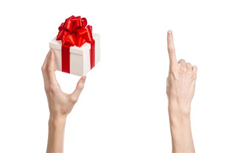 축 하와 선물의 테마 화이트 레드 리본 및 활 스튜디오에서 흰색 배경에 고립 된 가장 아름 다운 선물 상자에 포장 하는 선물을 들고 손 기념일에 대한 스톡 사진 및 기타