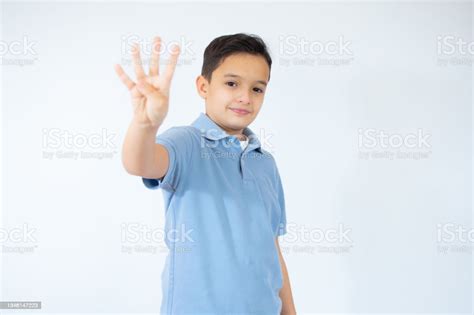 파란 티셔츠를 입고 고립 된 흰색 배경 위에 서서 자신감과 행복한 미소를 지으면서 손가락 번호 4를 가리키는 아름다운 아이 소년 가리키기에 대한 스톡 사진 및 기타 이미지