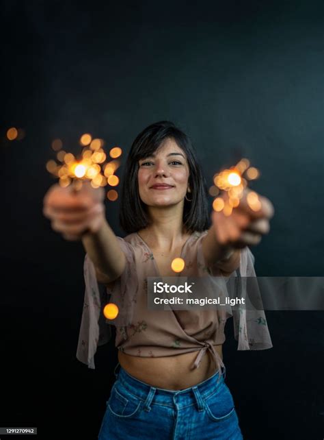벵골 조명을 들고 쾌활한 백인 소녀의 클로즈업 사진 반짝이는 검은 색 배경에 고립 된 빨간 잠옷을 입은 행복한 젊은 여성의 초상화 25 29세에 대한 스톡 사진 및 기타