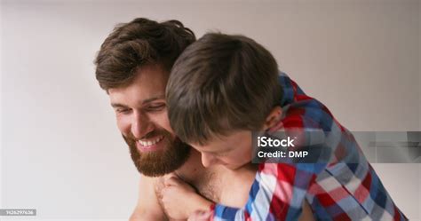 가족 포옹 및 아침 아버지와 자녀와 함께 놀고 침대에서 포옹하거나 돌보고 함께 일어납니다 아빠와 어린 아들과의 행복 재미 및 사랑 집에서 침실에서 웃거나 유대감을 느낍니다