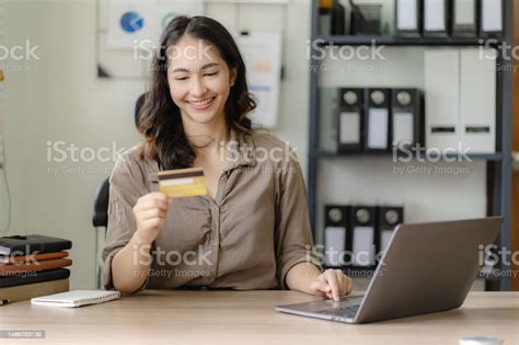 젊은 아시아 여성은 집에서 온라인 쇼핑을 위해 신용카드를 들고 성공적인 여성과 온라인 쇼핑 개념을 갖고 노트북으로 인터넷 서핑을 한다 경영자에 대한 스톡 사진 및 기타