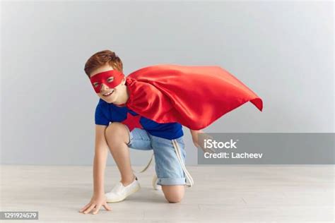 회색 배경에 악을 싸울 준비가 슈퍼 히어로 의상을 입고 쾌활한 소년 슈퍼맨인 척하는 긍정적 인 아이 8 9 살에 대한 스톡 사진 및 기타 이미지 Istock