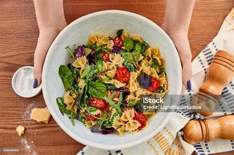 파마산 근처 파스타 샐러드와 나무 배경에 후추와 소금 공장 냅킨과 그릇을 들고 여자의 자른 보기 건강한 생활방식에 대한 스톡 사진 및 기타 이미지 Istock