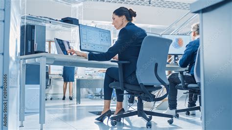 back view of team of technology engineers working on desktop computers