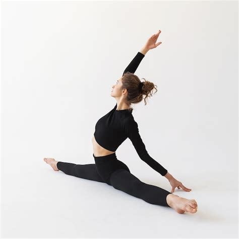 Premium Photo A Young Woman Is Engaged In Stretching The Muscles Of The Legs Performs A