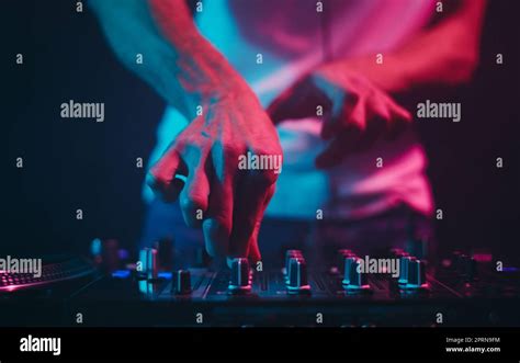 Hands Of A DJ Adjusting Volume Frequency Regulators On A Sound Mixer Professional Disc Jockey