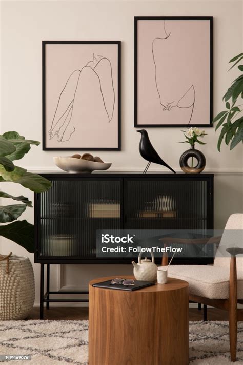 모형 포스터 프레임 유리 찬장 세련된 베이지색 그릇 둥근 커피 테이블 화분 식물 및 개인 액세서리가 있는 거실 인테리어 인테리어