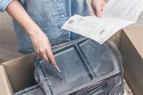 송장과 문구 칼을 들고 홈 오프닝 판지 상자에 바닥에 앉아 여성 구매자는 인터넷 상점에서 소포 패키지를 받았습니다 배달 서비스 맨 위 보기 가정의 방에 대한 스톡 사진 및