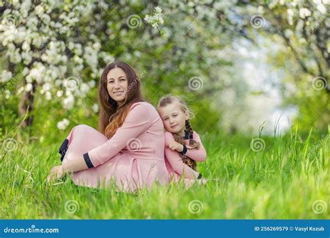 Moeder En Dochter In De Natuur Met Hun Rug Tegen Elkaar Stock