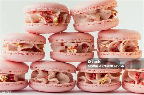 황금 꽃잎으로 장식 된 분홍색 딸기 마카롱과 동결 건조 된 빨간 열매가 피라미드 모양으로 함께 쌓여 있습니다 흰색 배경 클로즈업 샷 금색에 대한 스톡 사진 및 기타 이미지