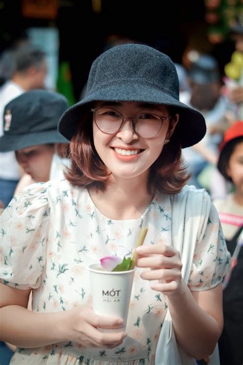 야외에서 허브 음료를 즐기는 미소 짓는 여성 · 무료 스톡 사진