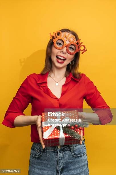 노란색 바탕에 크리스마스 상자를 손에 들고 있는 젊은 여성 크리스마스와 새해를 축하하는 개념입니다 12월 31일에 대한 스톡 사진 및 기타 이미지 Istock
